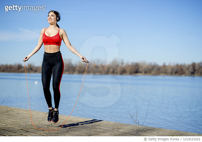1219121022 | 게티이미지코리아 | Young women jump roping by river Royalty-Free 이미지