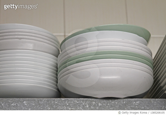 1385208105 | 게티이미지코리아 | Close-up of stack of plates in cupboard Royalty ...