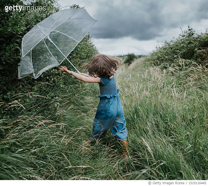 1519116445 | 게티이미지코리아 | A child looses control of her umbrella on a ...